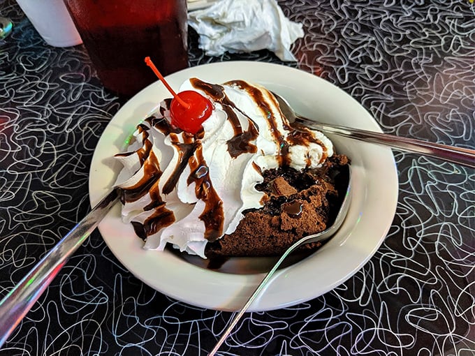 A brownie sundae that defies gravity with its mountain of whipped cream. The cherry on top isn't just garnish—it's the exclamation point.