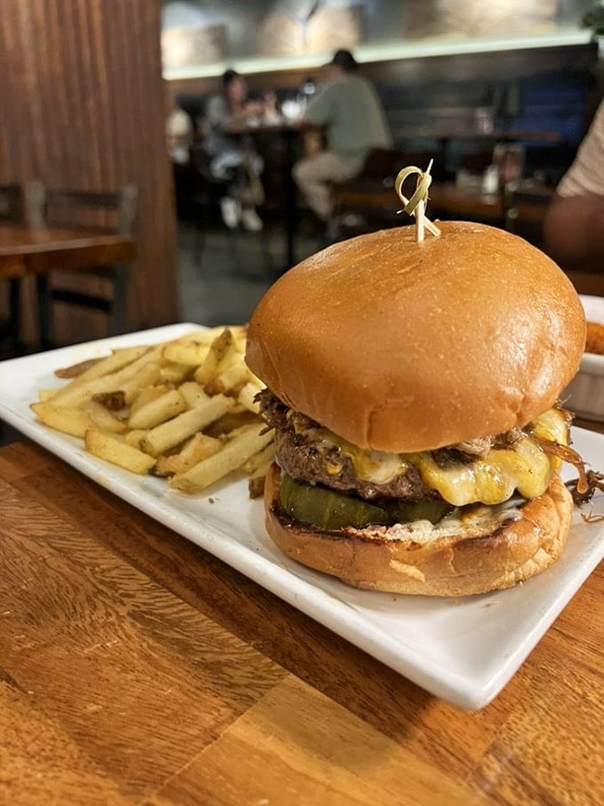 Not your average burger joint creation—this towering masterpiece balances beef, cheese, and pickles in perfect harmony. 