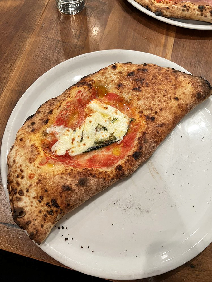 Half-moon of happiness! This calzone's golden-brown exterior gives way to a pocket of Italian bliss that's worth every delicious calorie.