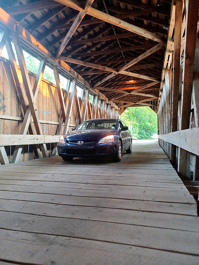 Slower than a walk isn't just a quaint suggestion—it's the law! This Honda driver follows rules established when horses pulled carriages through these same wooden corridors.