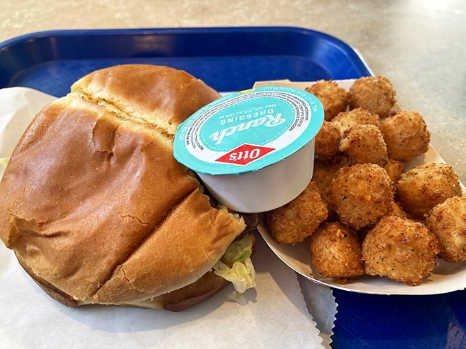 The ultimate comfort food combo – a hearty burger alongside golden-fried cheese cubes that somehow improve an already perfect meal.