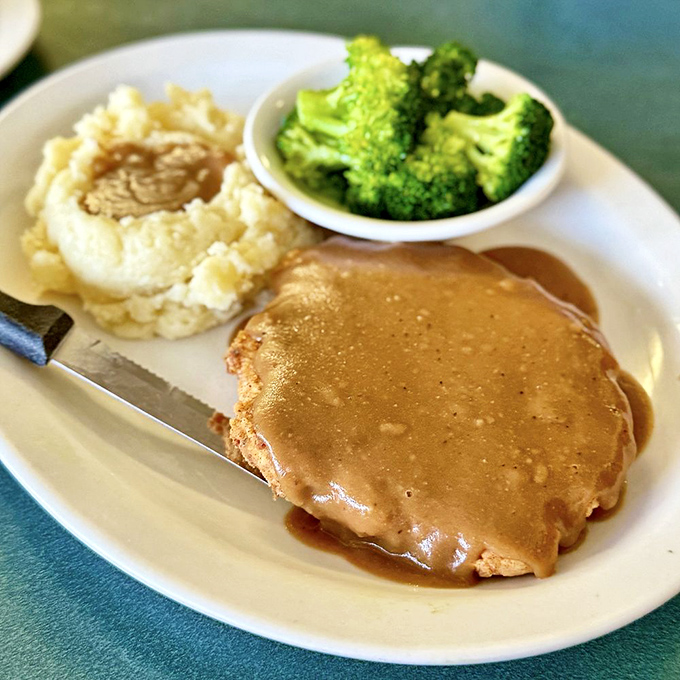 Country-fried steak swimming in gravy—proof that some of life's greatest pleasures don't need to be complicated, just perfectly executed.