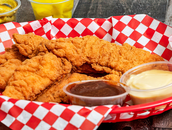 Golden-brown chicken tenders that crunch louder than your childhood memories, served with sauce that demands to be dunked.
