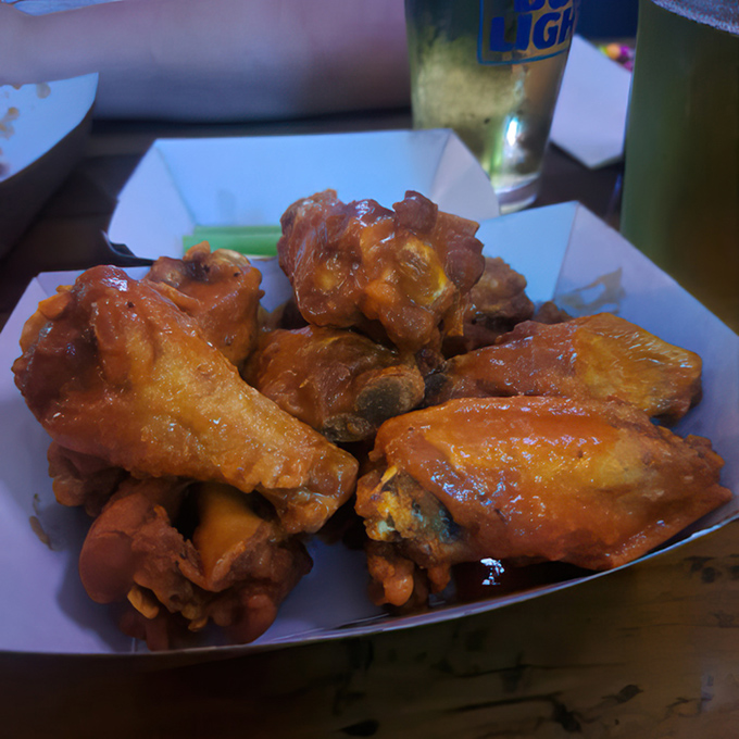 Wings glistening with sauce that promises to leave its mark on both your taste buds and possibly your shirt—a delicious risk worth taking.