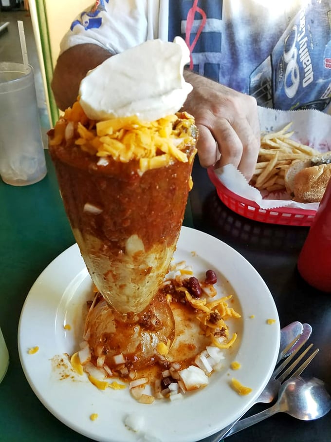 Behold the chili—standing tall in its edible bread bowl fortress, crowned with cheese and onions like the royalty of comfort food it truly is.