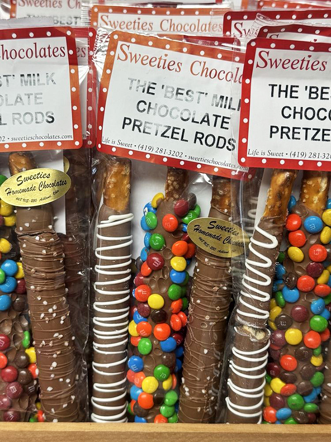 Chocolate pretzel rods dressed for success—some in tuxedo white chocolate, others flaunting colorful M&M confetti like they're heading to a party.