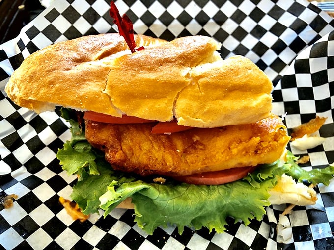 A sandwich so substantial it requires both hands and a strategy—crispy fish nestled between fresh greens and pillowy bread.