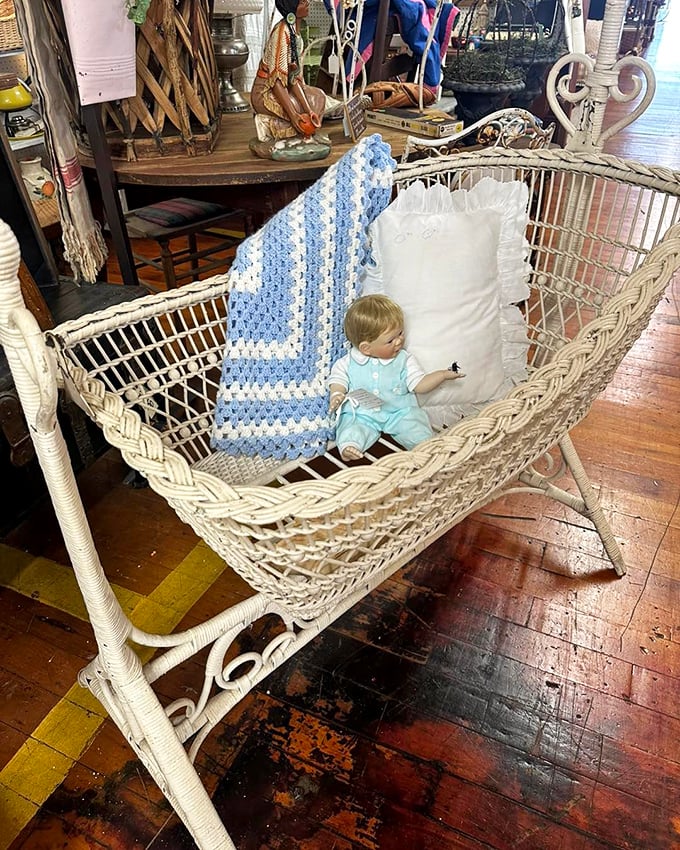 A wicker baby cradle that's rocked generations to sleep now waits for its next chapter—complete with vintage doll that's either adorable or the start of a horror movie.