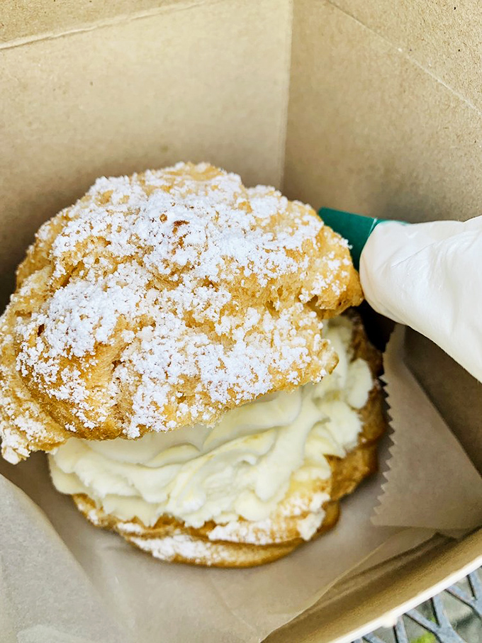 This cream puff isn't just dessert, it's architecture – a delicate structure housing a cloud of cream that demands to be photographed before devoured.