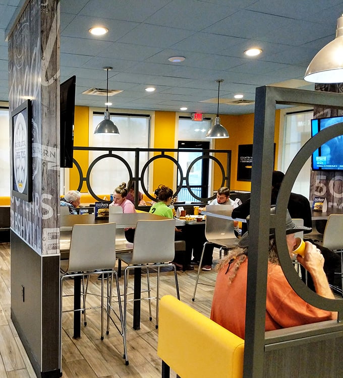 The modern interior features bright yellow accents and comfortable seating where locals gather to worship at the altar of proper biscuits.