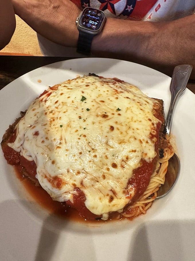 Behold the chicken parmigiana—a mountain of melted cheese cascading over perfectly seasoned chicken, with spaghetti standing by for the flavor party.