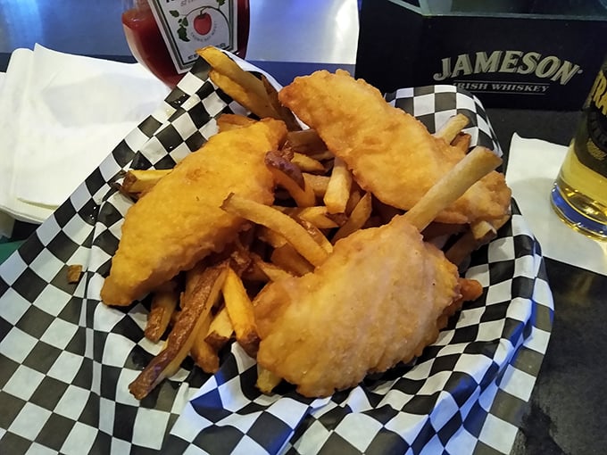 Fish and chips served in a checkered basket—the universal signal that you're about to experience something gloriously unpretentious and utterly satisfying.