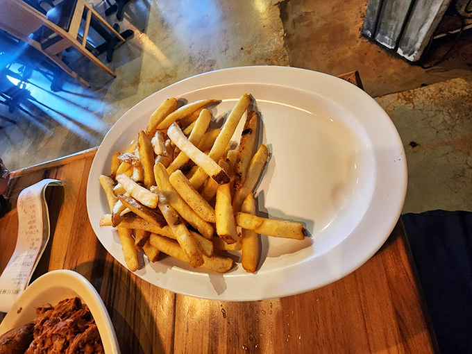 Golden fries scattered like edible confetti – the perfect vehicle for soaking up every drop of that precious barbecue sauce.