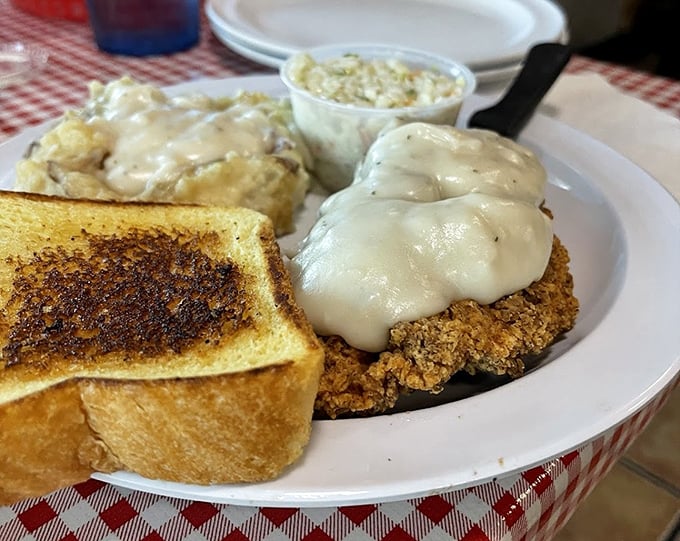 Country fried steak smothered in gravy – because sometimes the most comforting foods are the ones that completely obscure your view of the plate beneath.
