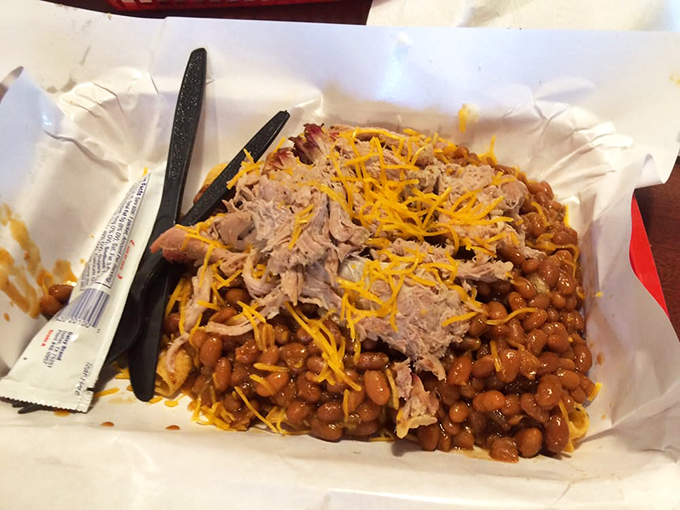 Frito pie topped with pulled pork and cheese—proof that sometimes the best culinary ideas sound like they came from a midnight refrigerator raid.