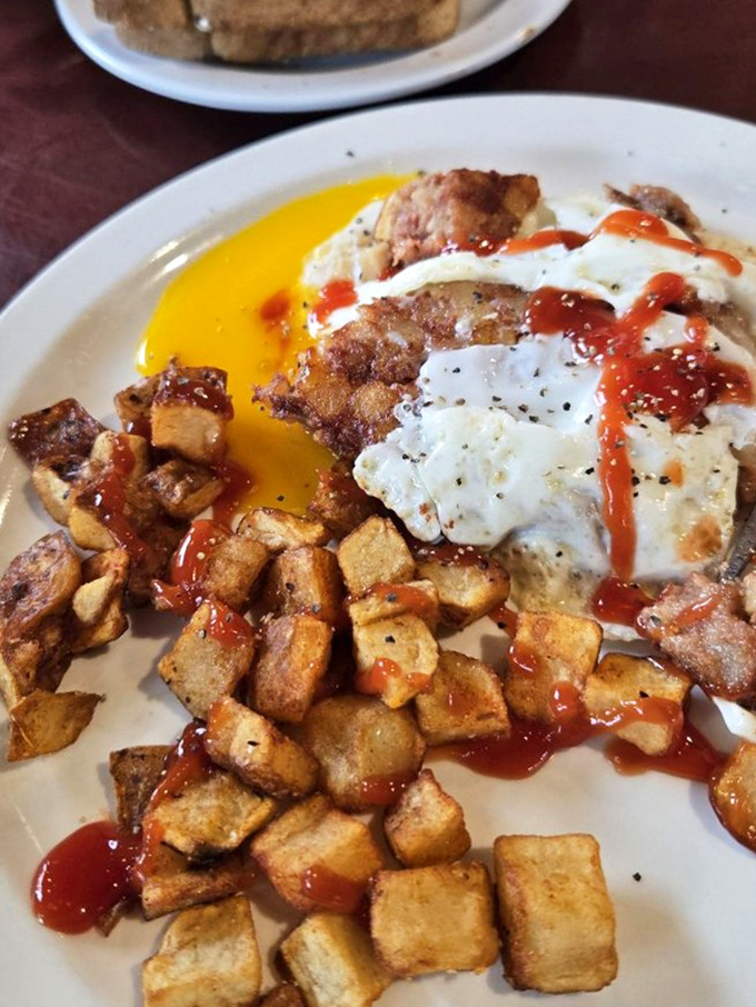 Home fries, eggs, and a splash of hot sauce—breakfast's holy trinity served with a side of "why don't I make this at home?" (Because it wouldn't taste this good.)