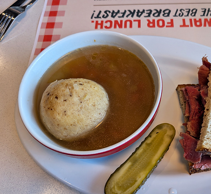 A matzo ball floating like the moon in a savory universe—this soup has been solving problems since before therapy was invented.