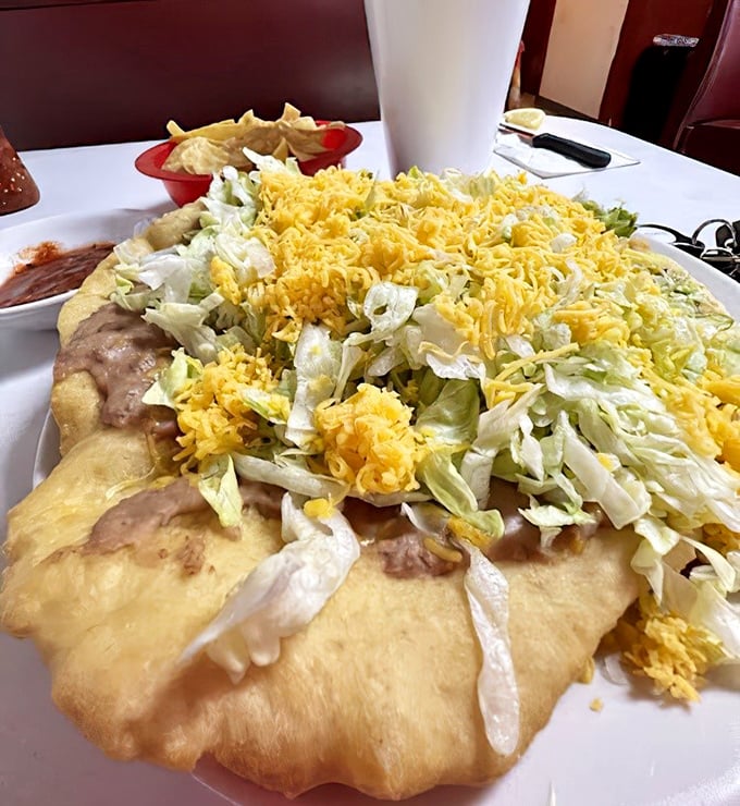 The Navajo Taco arrives like an edible monument – fry bread supporting a skyscraper of beans, cheese, lettuce and pure happiness.