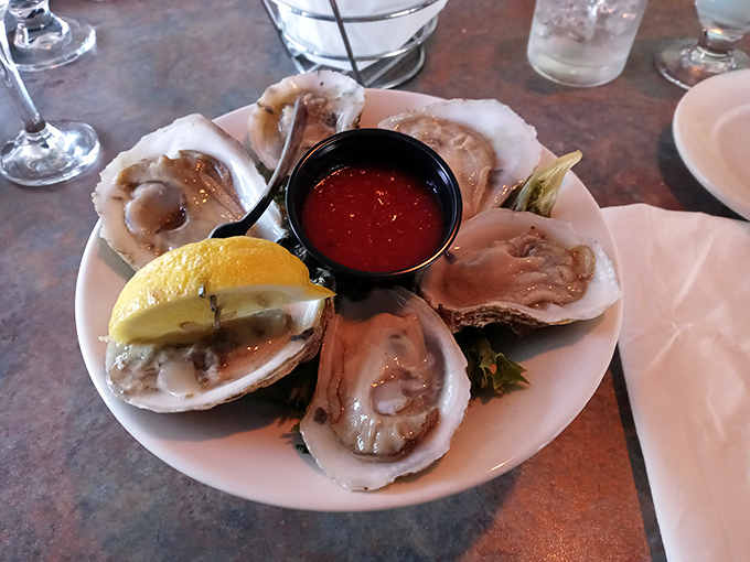 These oysters aren't just served – they're presented like the briny jewels they are, with cocktail sauce standing by for those who insist.