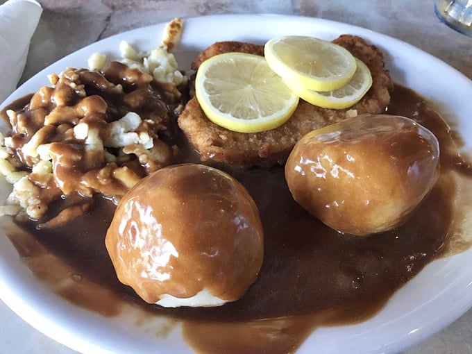 These potato dumplings swim in rich gravy alongside perfectly golden schnitzel—a plate that whispers "take a nap after lunch" in the most delicious way possible.