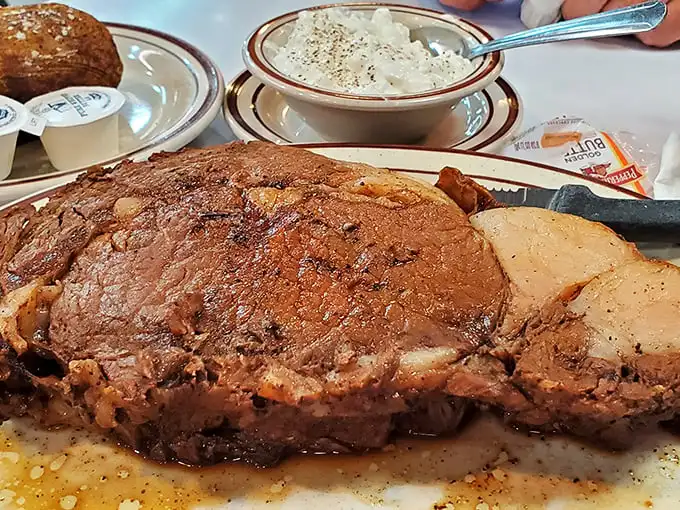 A prime rib so magnificent it deserves its own Instagram account—tender, juicy, and taking up real estate on that plate like it owns the deed.