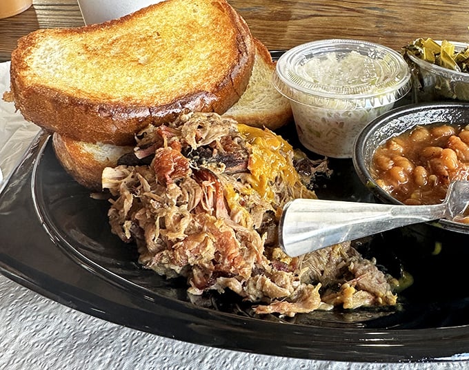 This pulled pork sandwich with slaw and beans isn't just lunch—it's edible evidence that patience and smoke create magic that fast food can never match.