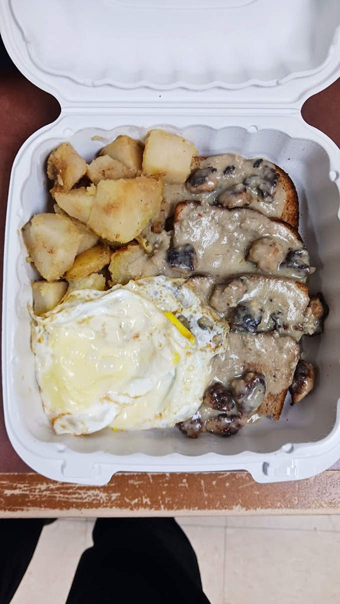 Sausage gravy cascading over toast like a breakfast waterfall, with home fries playing the perfect supporting role.