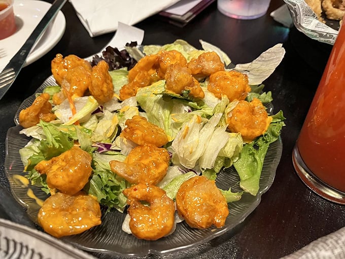 Buffalo-style shrimp perched atop crisp lettuce—proof that sometimes the best things in life come in small, sauce-covered packages.