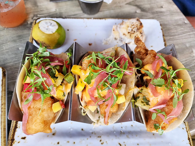 These fish tacos are dressed better than most wedding guests—vibrant mango salsa and pickled onions creating a fiesta in every bite.
