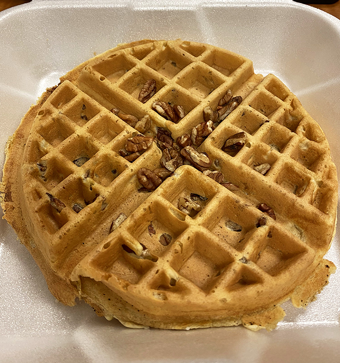 This waffle doesn't need fancy toppings to impress—just perfectly golden squares creating little pools for butter and syrup. The pecans add that "I'm an adult" touch.