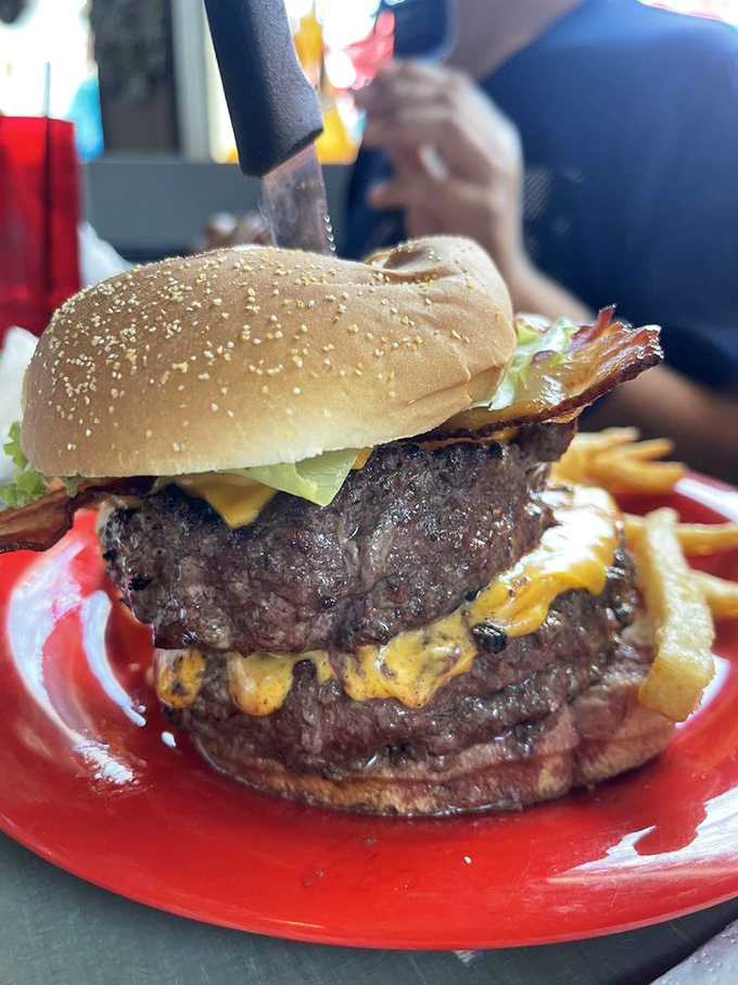 This isn't just a burger—it's a skyscraper of beef with melted cheese waterfalls. The kind of sandwich that requires jaw exercises and absolutely no first-date ordering.
