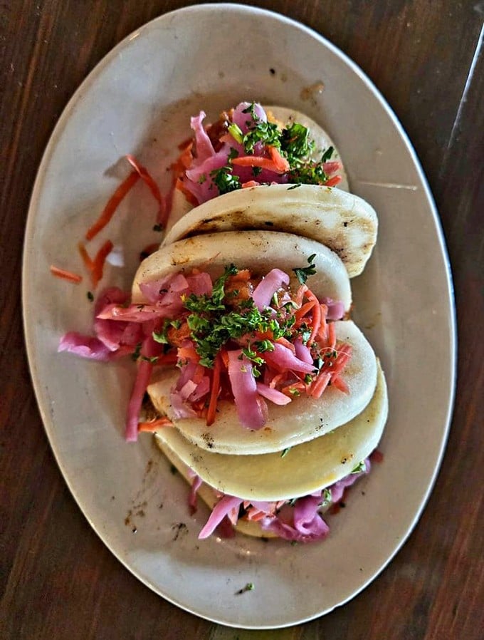 These bao buns aren't just a meal—they're little pillowy clouds carrying vibrant slaw and spice straight to your happiness center.