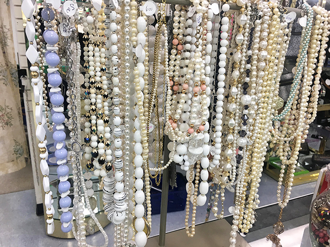 Pearl and bead necklaces cascade like frozen waterfalls—each strand waiting to transform an ordinary outfit into something grandmother-approved fabulous. 