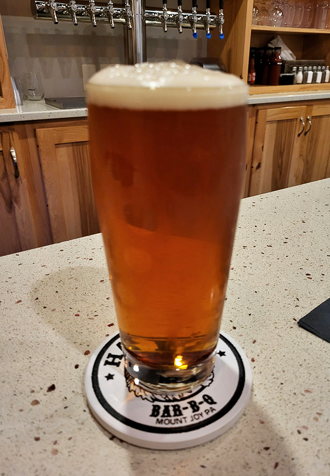 A cold craft beer in a Harvey's branded glass—because what pairs better with hours of smoked perfection than something that took similar patience to brew?