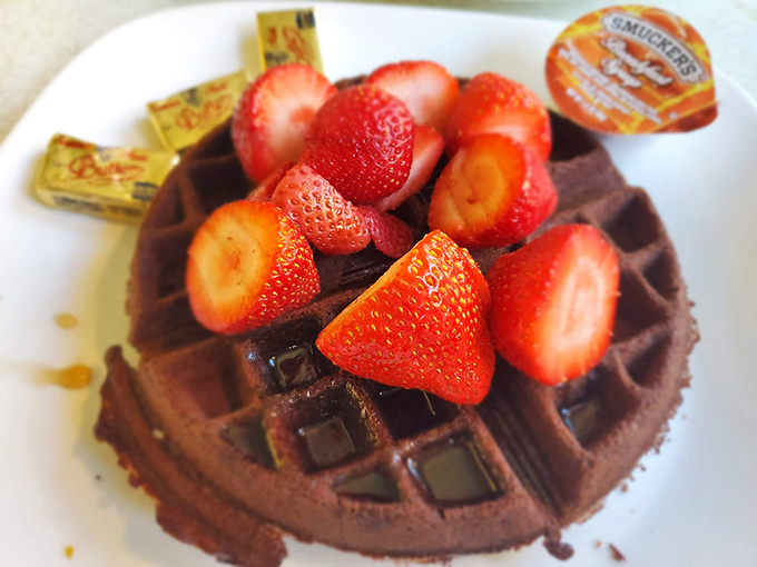 A chocolate waffle crowned with fresh strawberries – proof that breakfast and dessert are really just distant cousins.