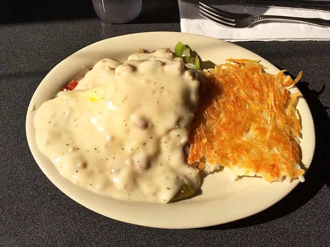 Country gravy cascading over fresh biscuits with the golden crown of hash browns—breakfast that fuels a day of adventure.