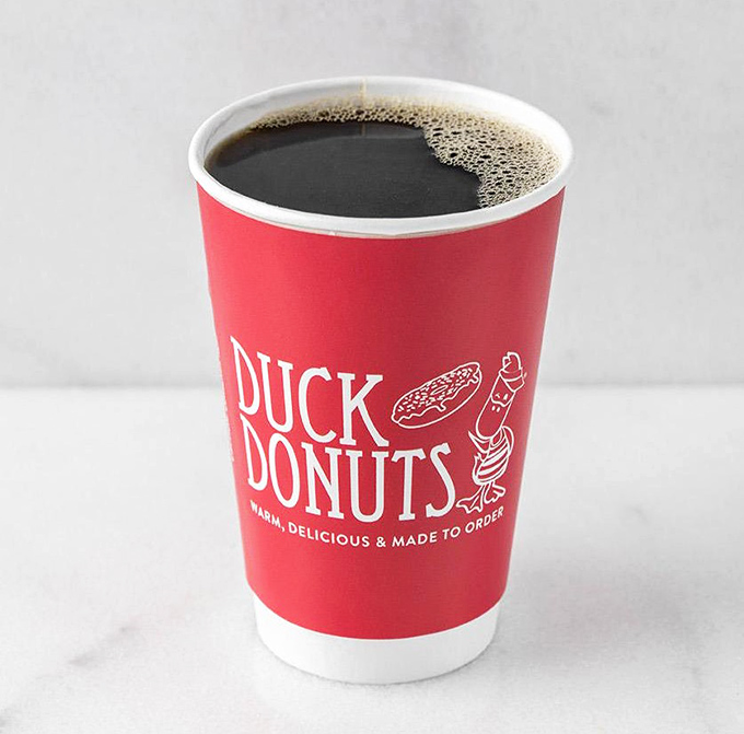 Simple black coffee in a cheerful red cup—because even purists deserve a happy morning.