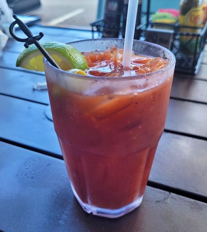 A proper Bloody Mary garnished with lime and a tiny sword—because sometimes breakfast needs reinforcements of the liquid variety.