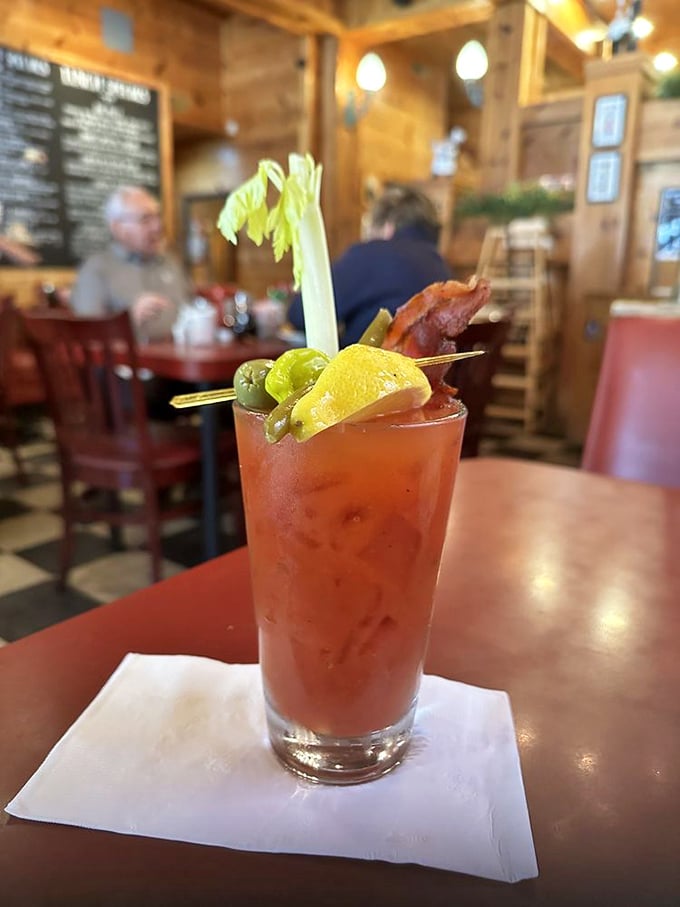 This Bloody Mary isn't just a drink—it's a garden party in a glass, complete with celery stalk skyscraper and bacon that refuses to be just a garnish.