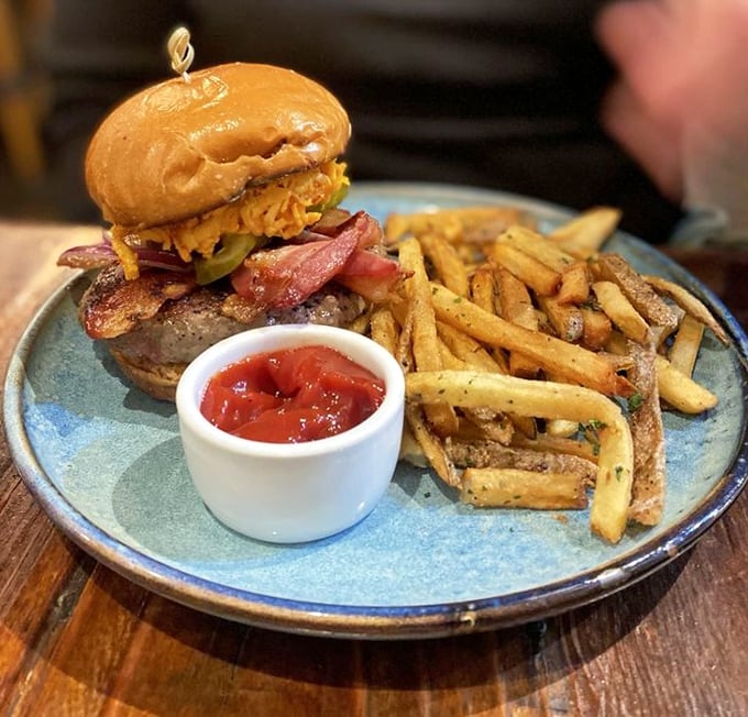 This burger doesn't need a fancy name—just look at those perfectly golden fries, the melty cheese, and that glistening bacon. Napkins required, regrets impossible.
