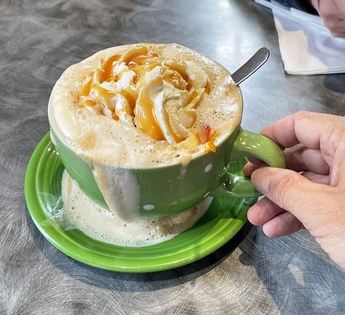 Coffee elevated to an art form. This caramel-drizzled creation in its polka-dotted green mug isn't just a beverage—it's morning motivation in liquid form.