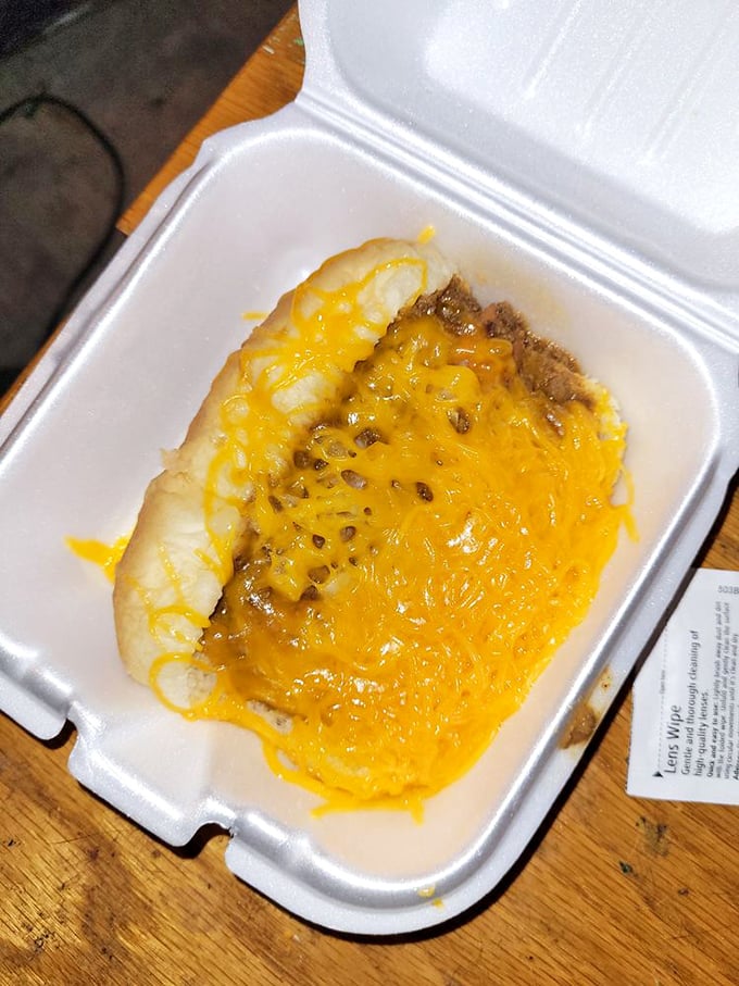Cincinnati's iconic cheese coney in its takeout glory. That vibrant yellow cheese practically glows with deliciousness against the chili beneath.