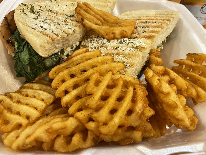 Waffle fries and a sandwich that requires both hands and several napkins—the universal language of "worth the mess." 