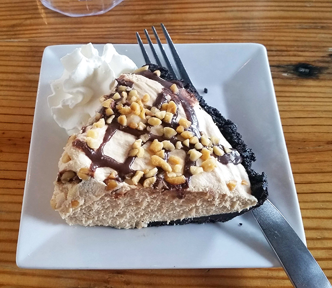 Chocolate peanut butter pie that would make Reese's weep with jealousy – the kind of dessert that justifies the entire concept of saving room.