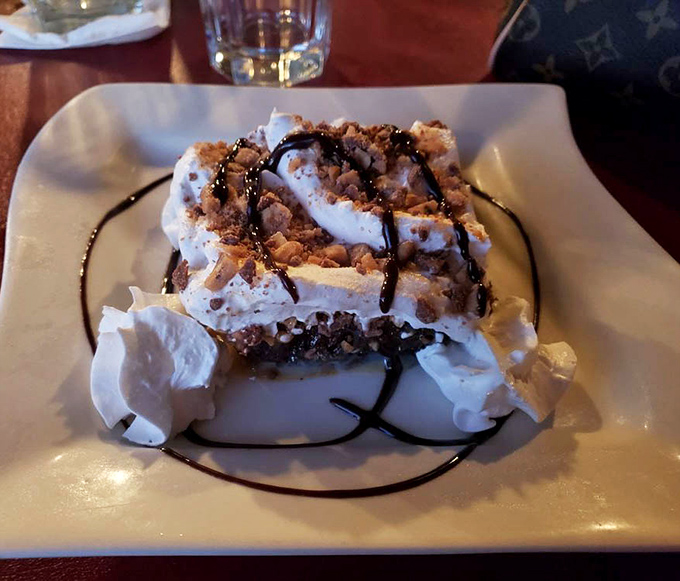 This isn't just chocolate cake—it's a towering monument to indulgence with whipped cream and chocolate drizzle for good measure.