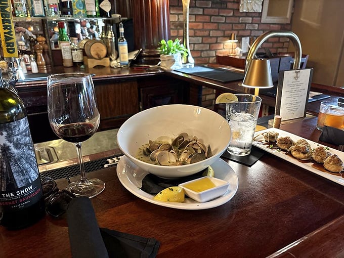 Fresh clams swimming in broth with a glass of wine standing by. This is what civilized eating looks like, folks.