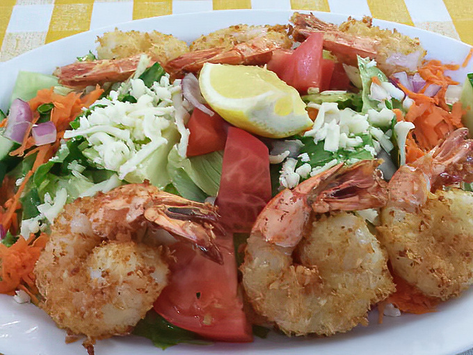 Coconut shrimp perched like sentinels around a fresh salad—proof that "healthy option" doesn't have to mean "sad option."