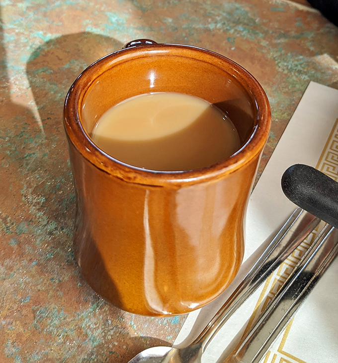 The humble coffee mug—steady companion to countless conversations and contemplations. In diners like this, refills come with knowing nods, not pretentious pours.