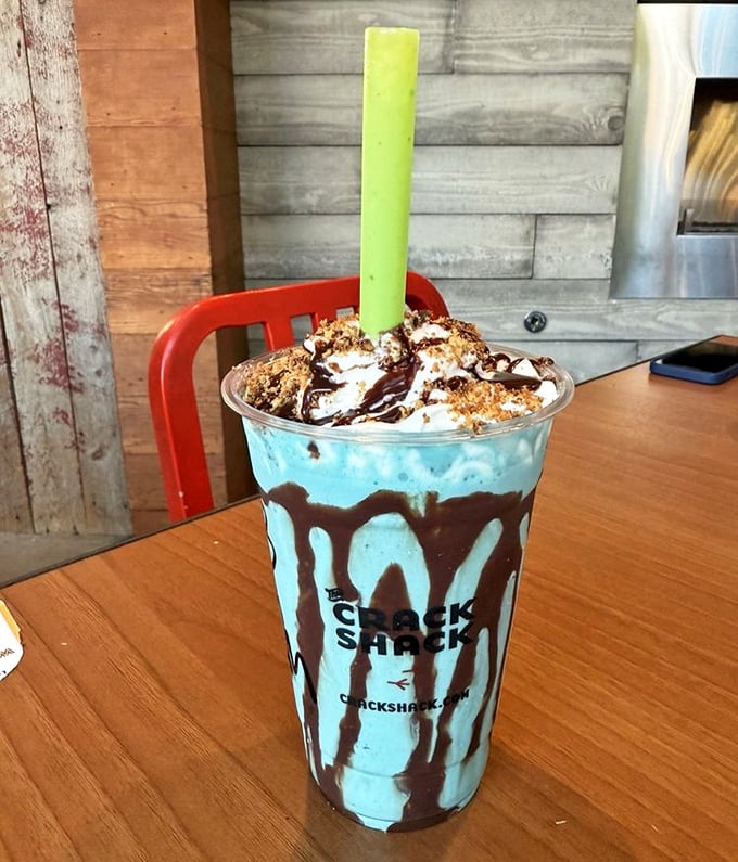 This isn't just a milkshake—it's dessert architecture, with chocolate cascading down blue soft-serve like a sweet Jackson Pollock painting.