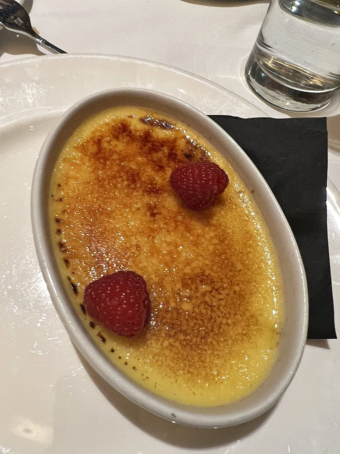 The crème brûlée's crackling sugar top gives way to silky custard beneath—like breaking through ice to find treasure.